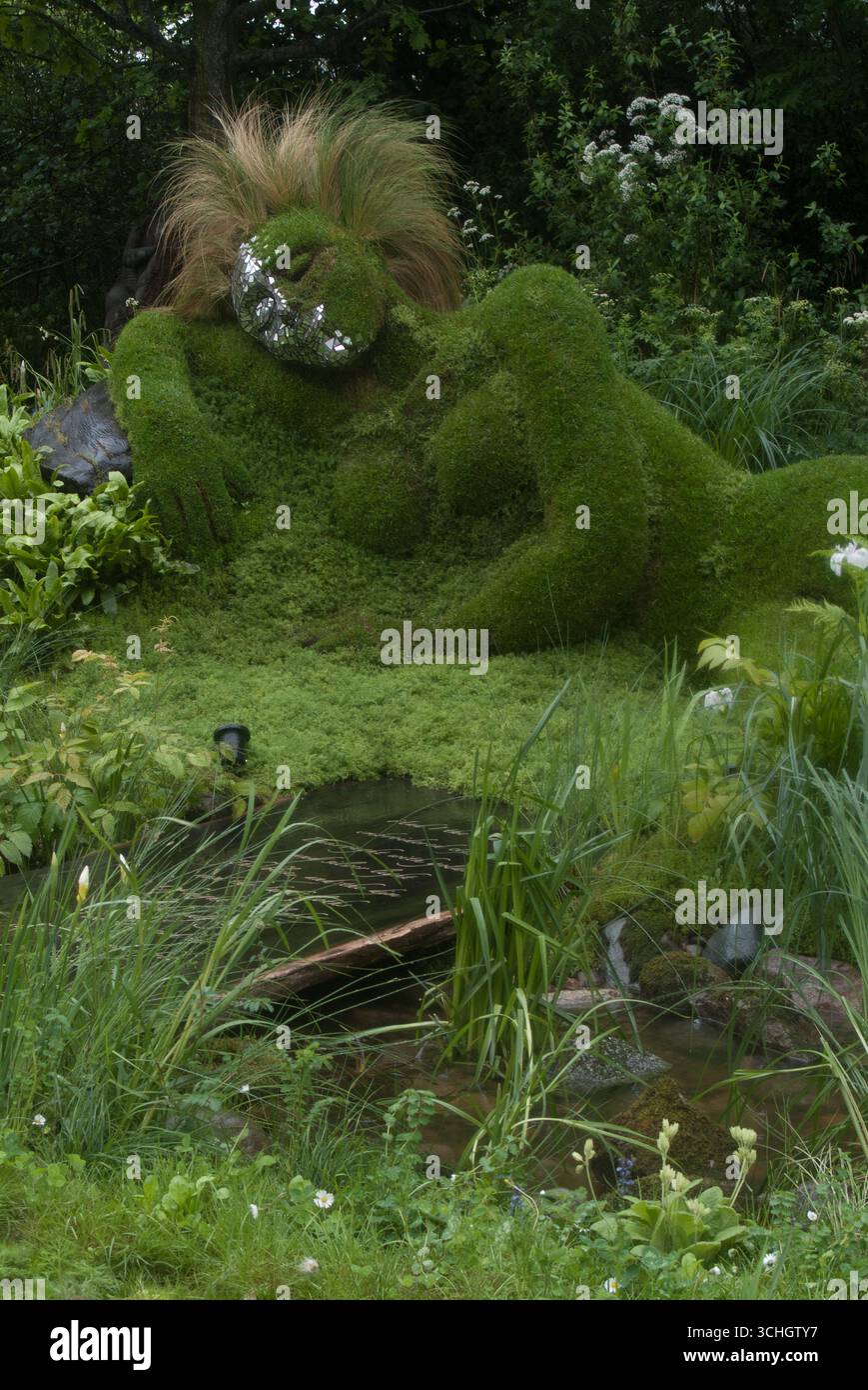 A unique sculpture made of grass and moss depicts a reclining figure ...
