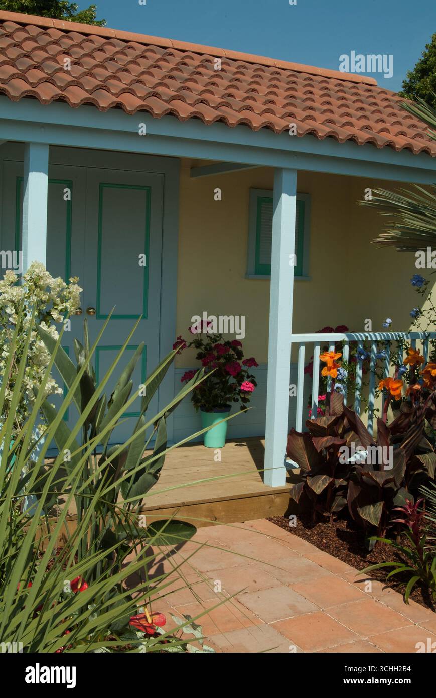 A lovely cottage features a quaint porch adorned with bright flowers ...