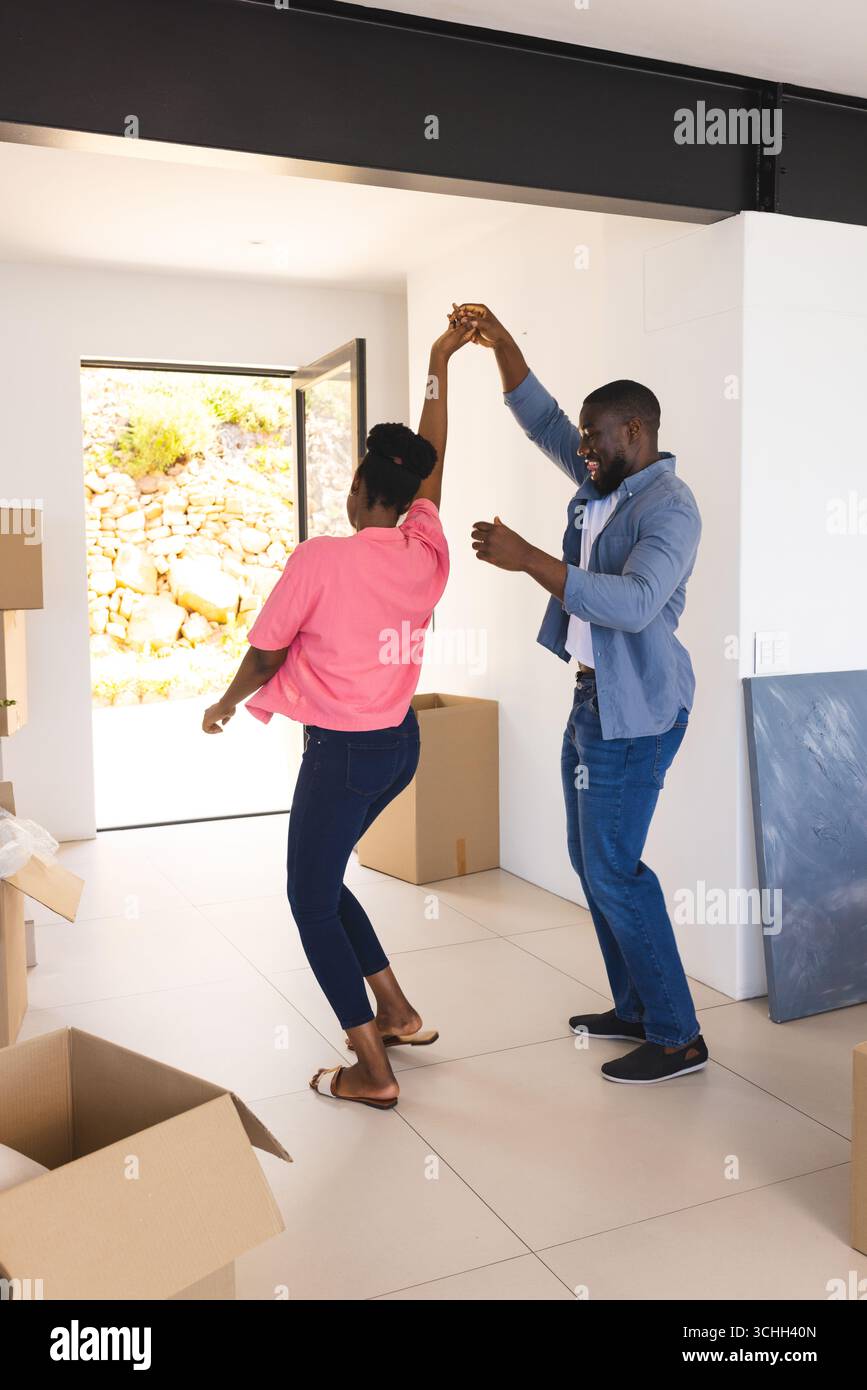 Couple dancing joyfully in new home surrounded by moving boxes Stock ...