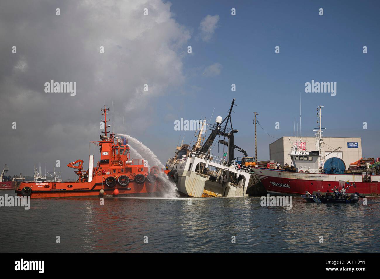 Emergency Services agents work to extinguish the fire on the ship Awadi ...