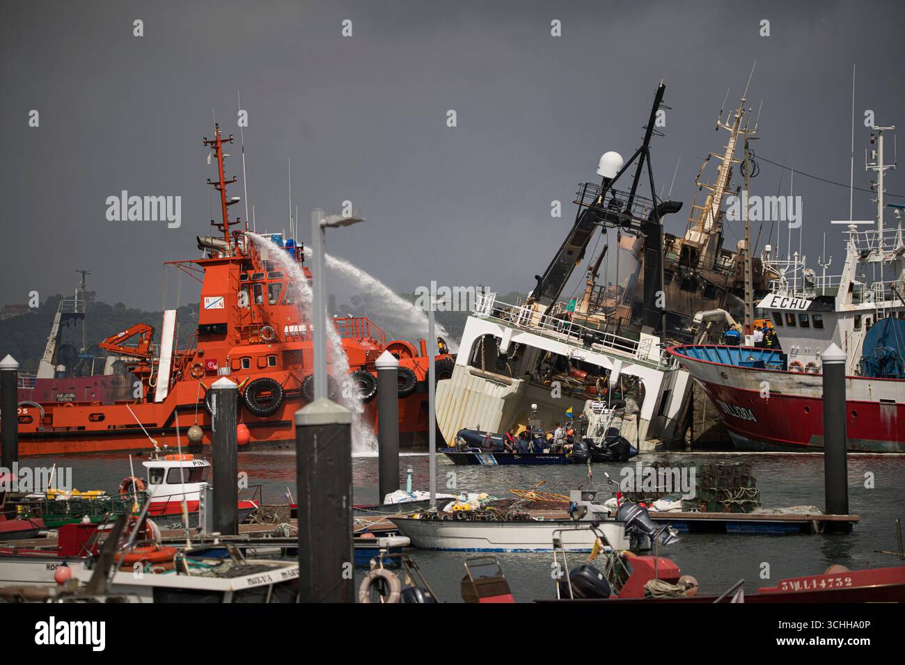 Emergency Services agents work to extinguish the fire on the ship Awadi ...