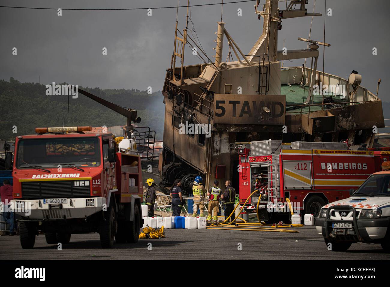 Emergency Services agents work to extinguish the fire on the ship Awadi ...