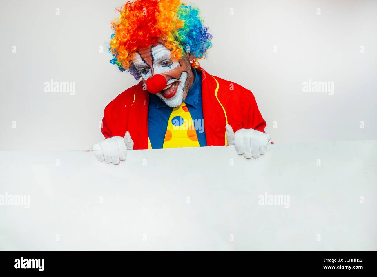 Clown looking down at blank poster Stock Photo - Alamy