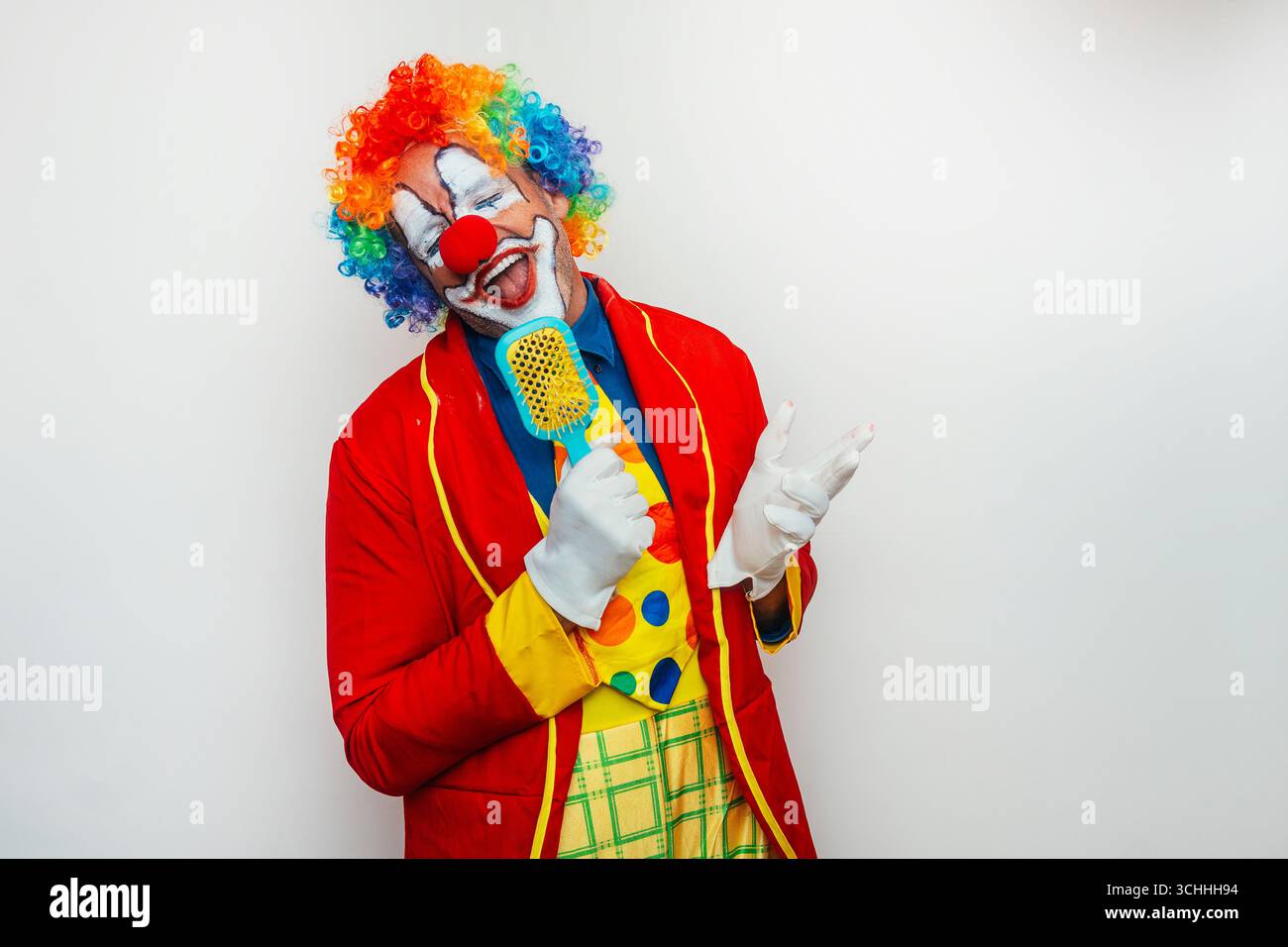 Clown singing with hairbrush as microphone Stock Photo - Alamy