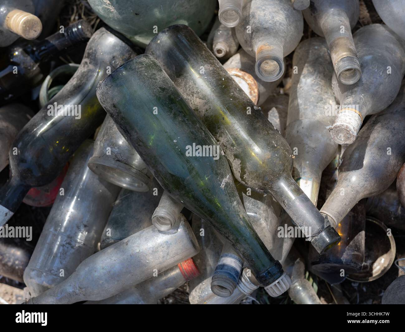 A pile of dirty and dusty glass bottles, old discarded waste, recycling ...