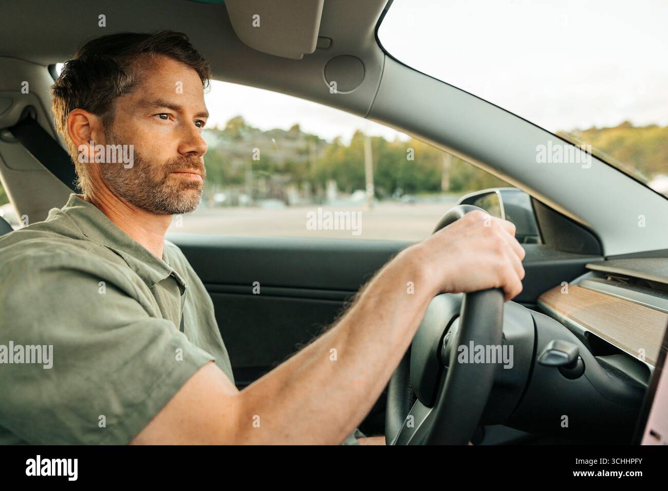 Focused man driving car with hand on steering wheel Stock Photo - Alamy