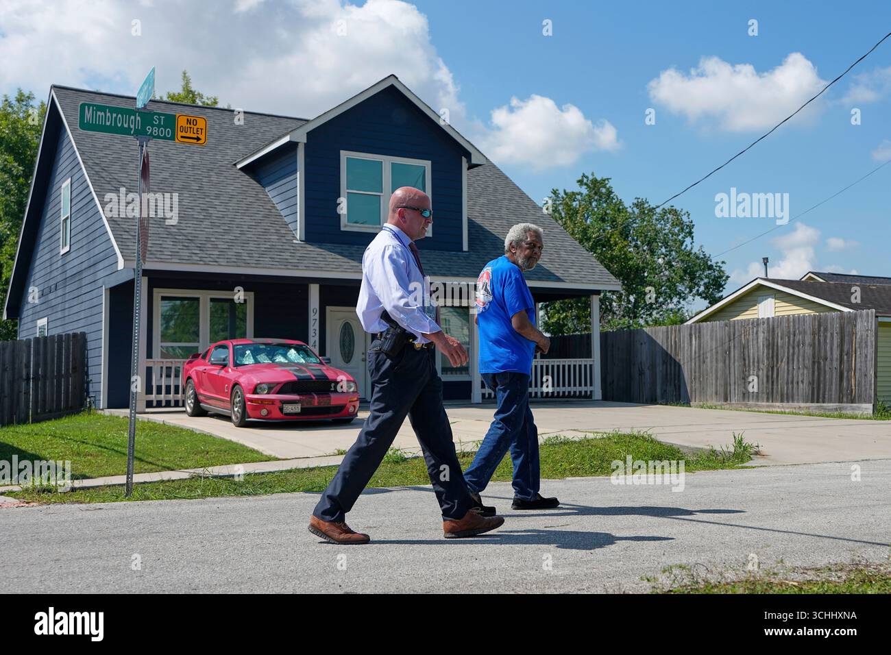 Neighbor George Skinner, right, talks a police investigator outside a ...