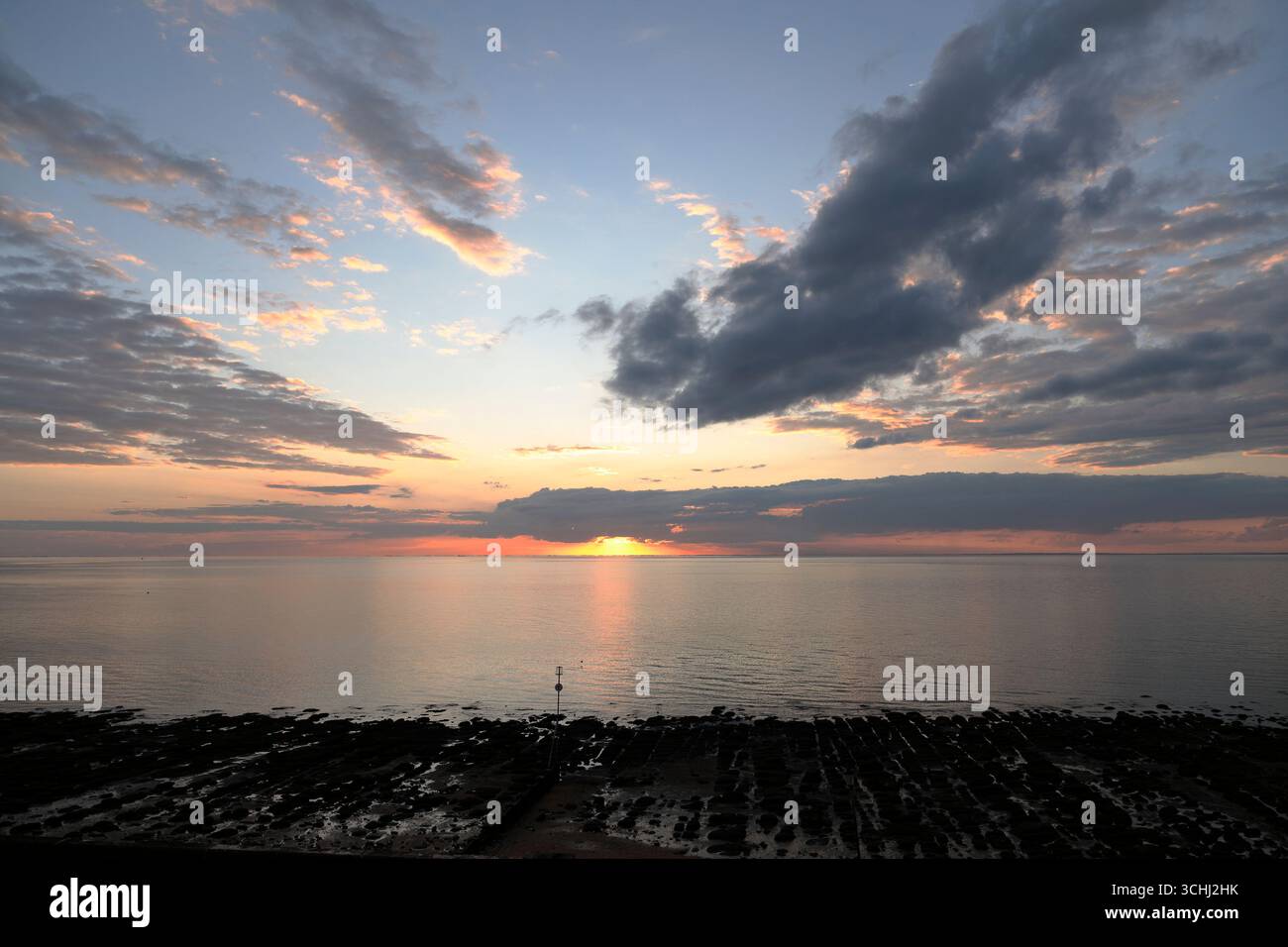 A beautiful sunset over Hunstanton beach, with low cloud and the orange ...