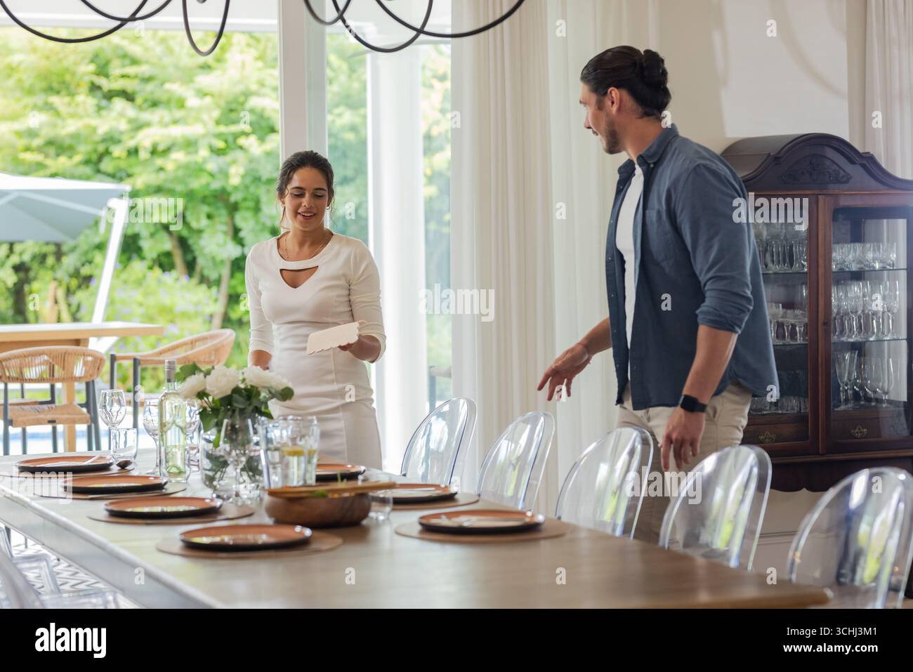 Preparing elegant dining table for wedding, couple smiling and ...