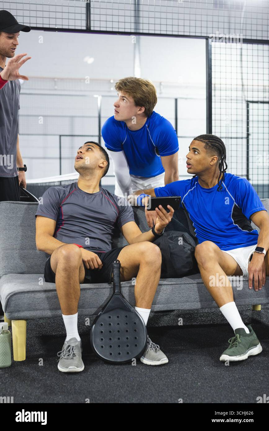 Diverse group of male athletes with coach coaching with paddle and ...