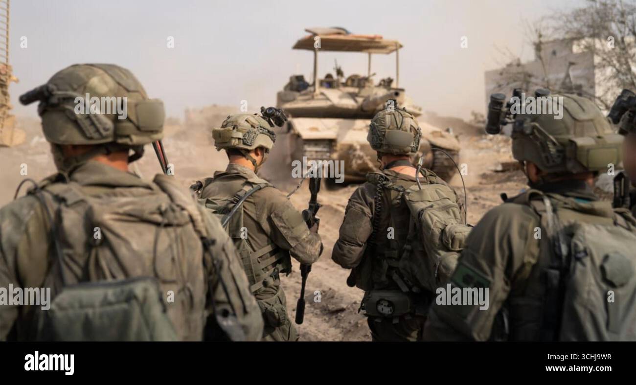 IDF (Israeli Defence Forces) soldiers following an APC in Gaza in 2025 ...