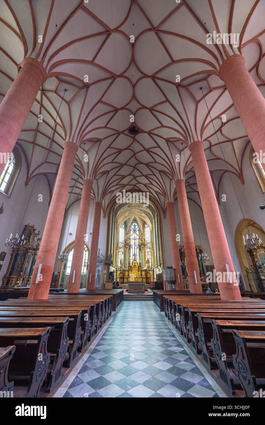 Historic gothic church interior with vaulted ceiling and ornate altar ...