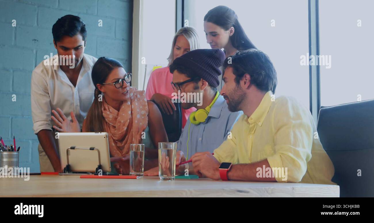 Collaborating six office professionals leaning over table in meeting ...