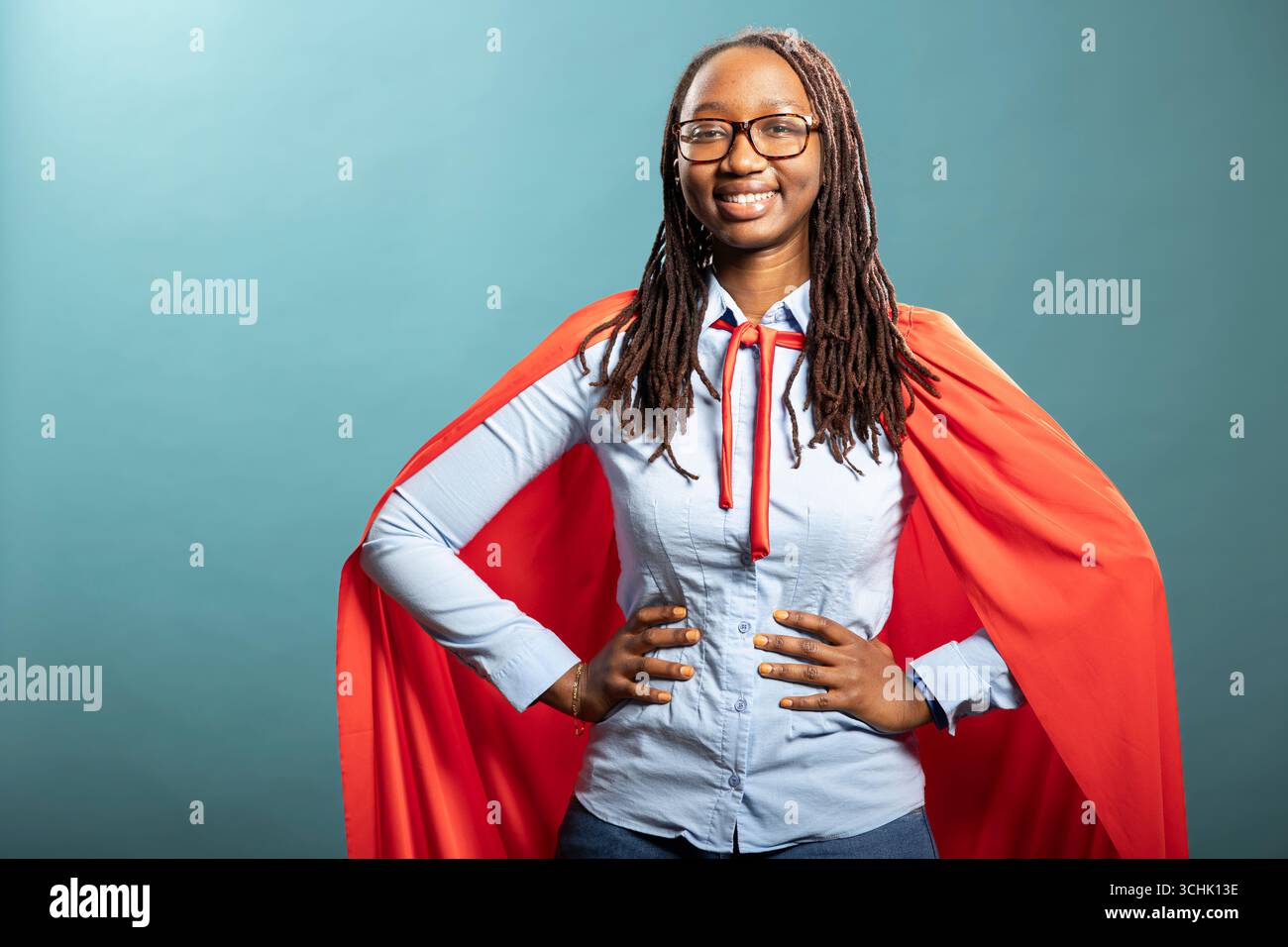 Vibrant black woman in superhero stance, wearing red cape, embodies ...