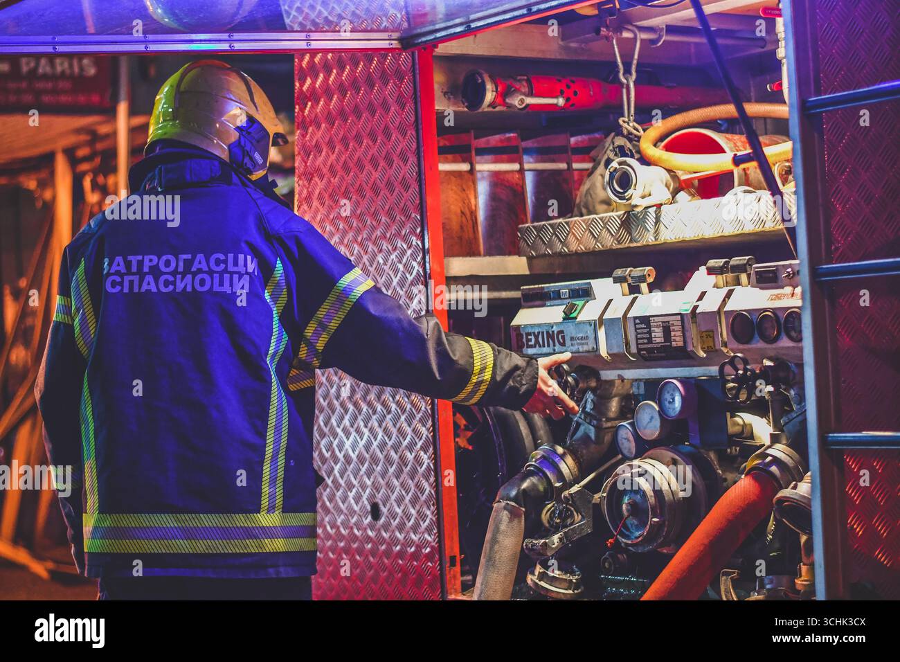 Firefighters in full gear extinguishing a large blaze. Thick smoke and ...