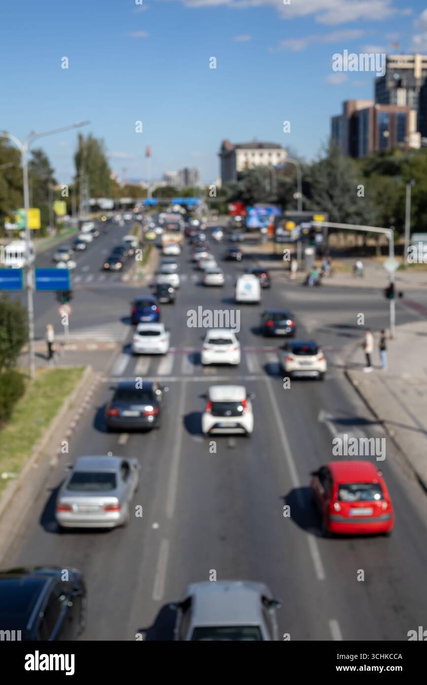 A blurred, wide-angle shot of a busy highway intersection on a sunny ...