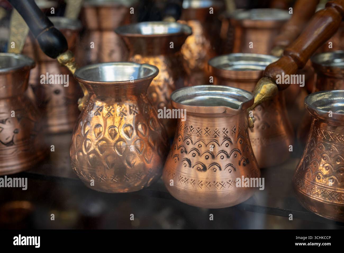 A close-up shot of multiple handmade copper coffee pots, known as ...