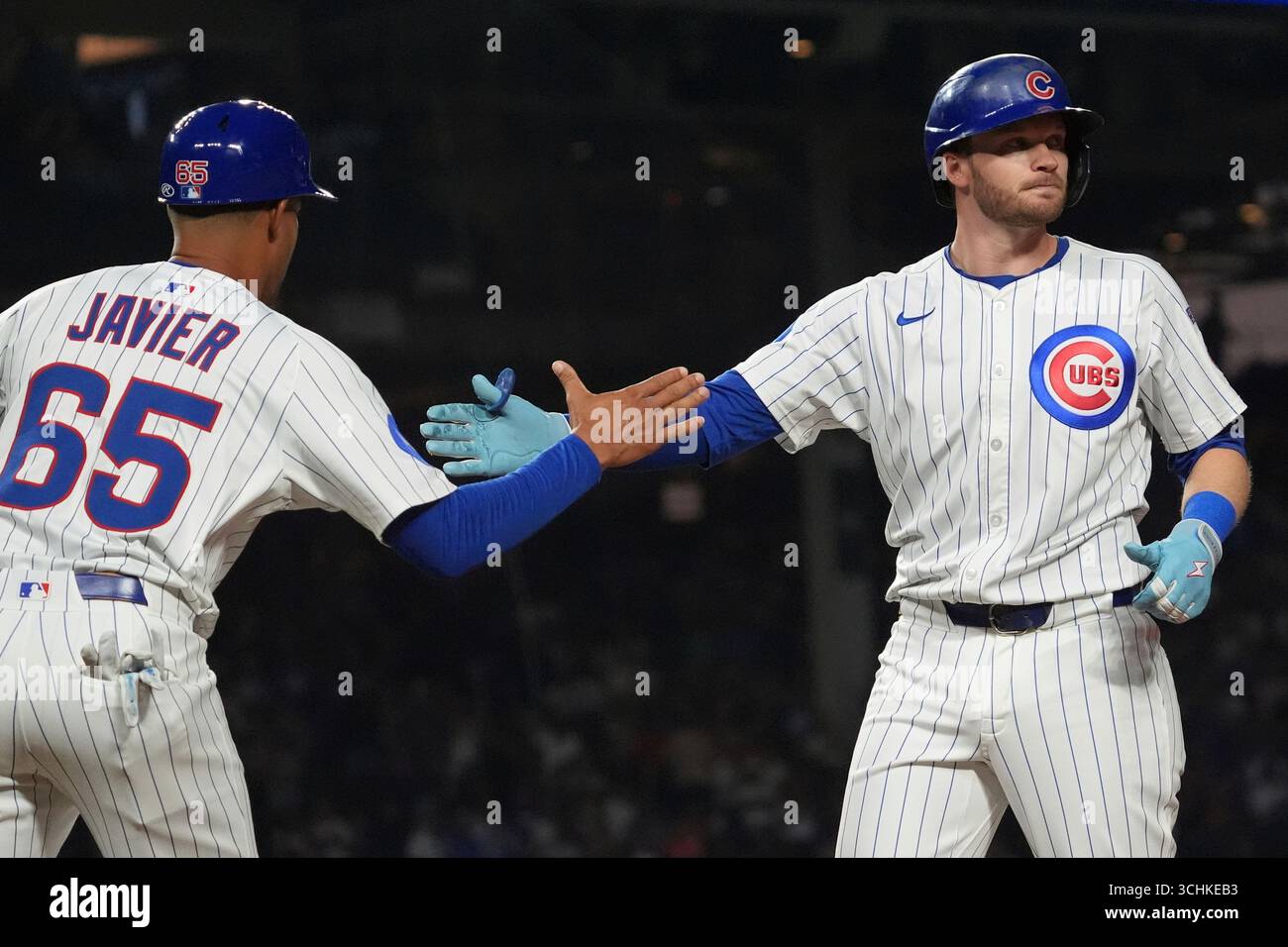 Chicago Cubs' Ian Happ, right, celebrates with first base coach Jose ...