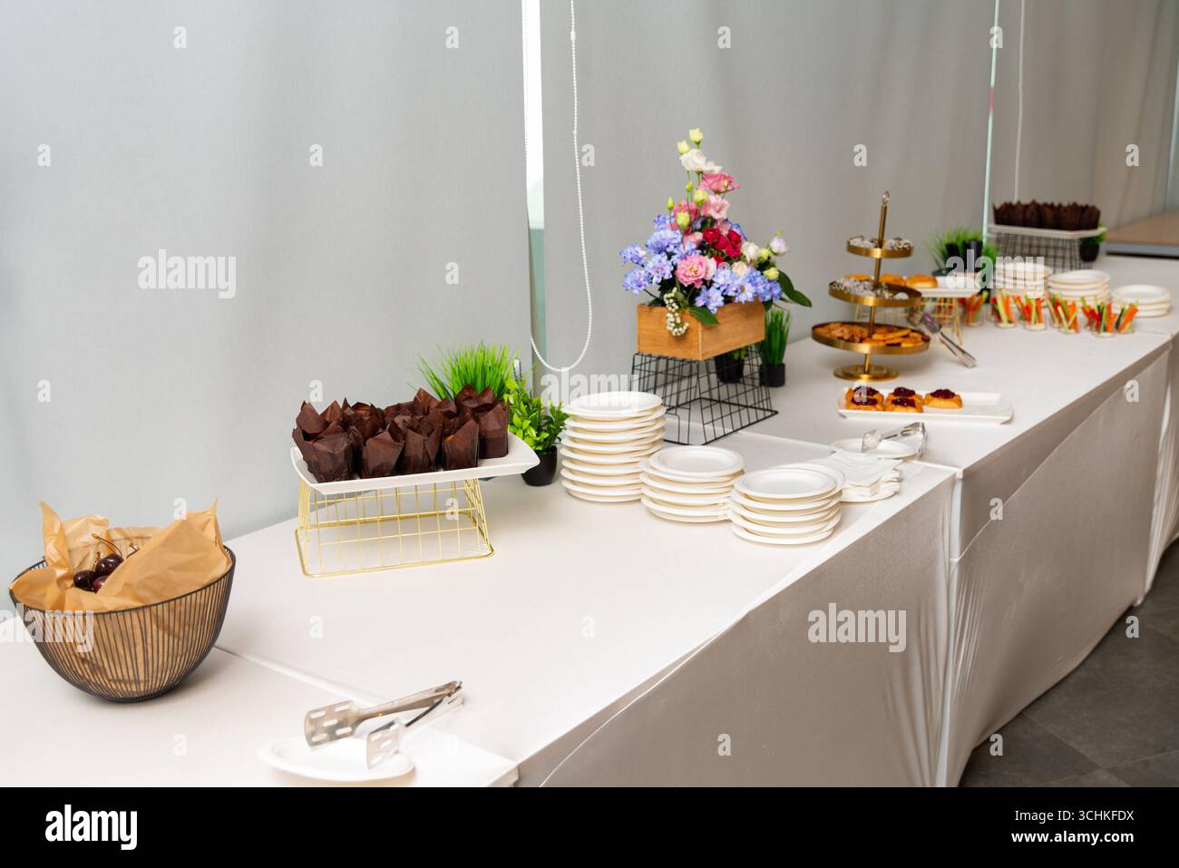 A beautifully arranged buffet table features an assortment of desserts ...