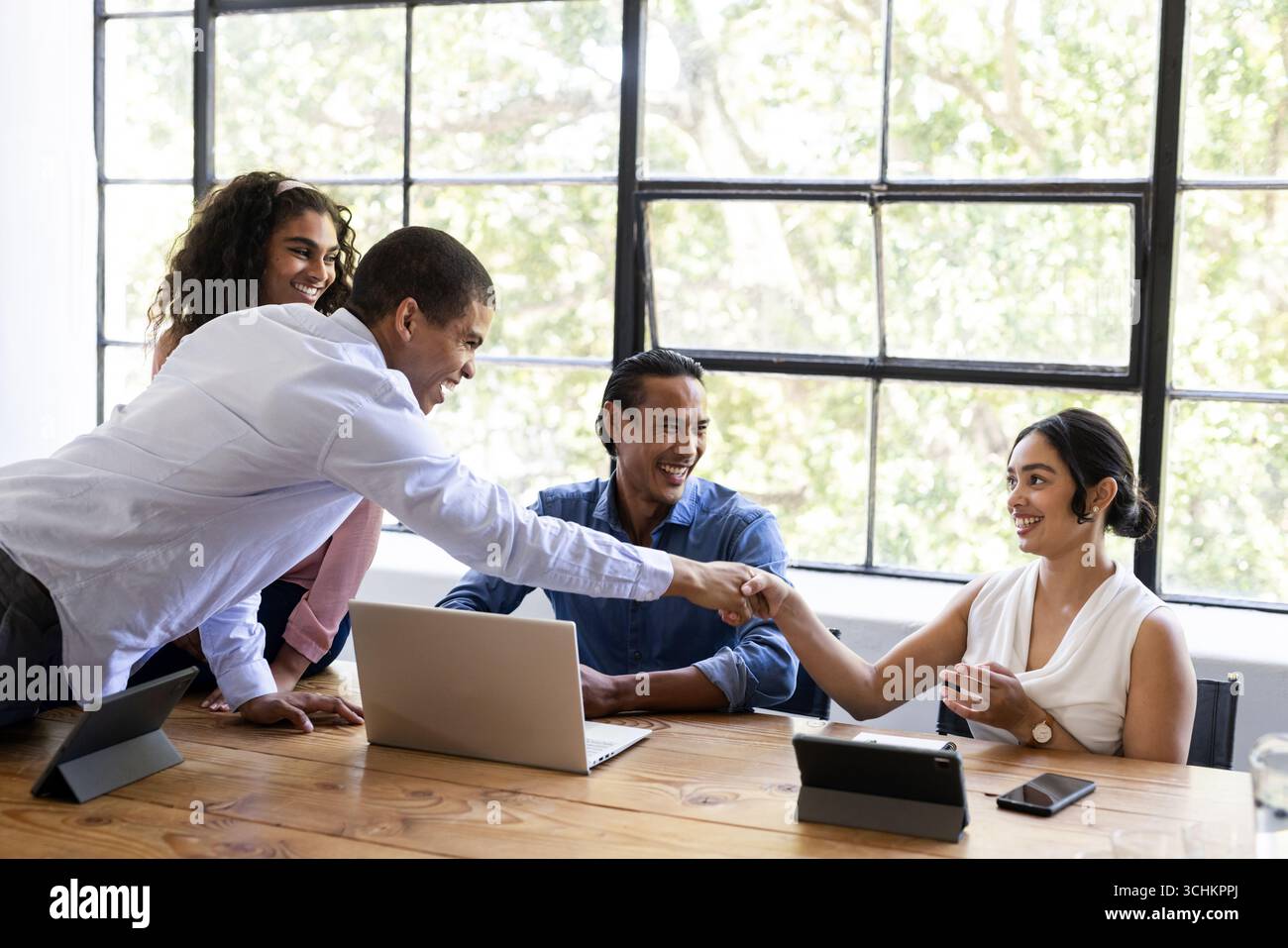 Diverse business team collaborating at office, shaking hands and ...