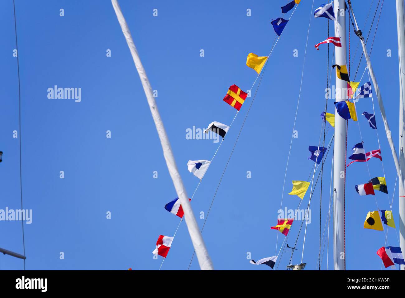 Flags on ship mast lines with blue sky background Stock Photo - Alamy