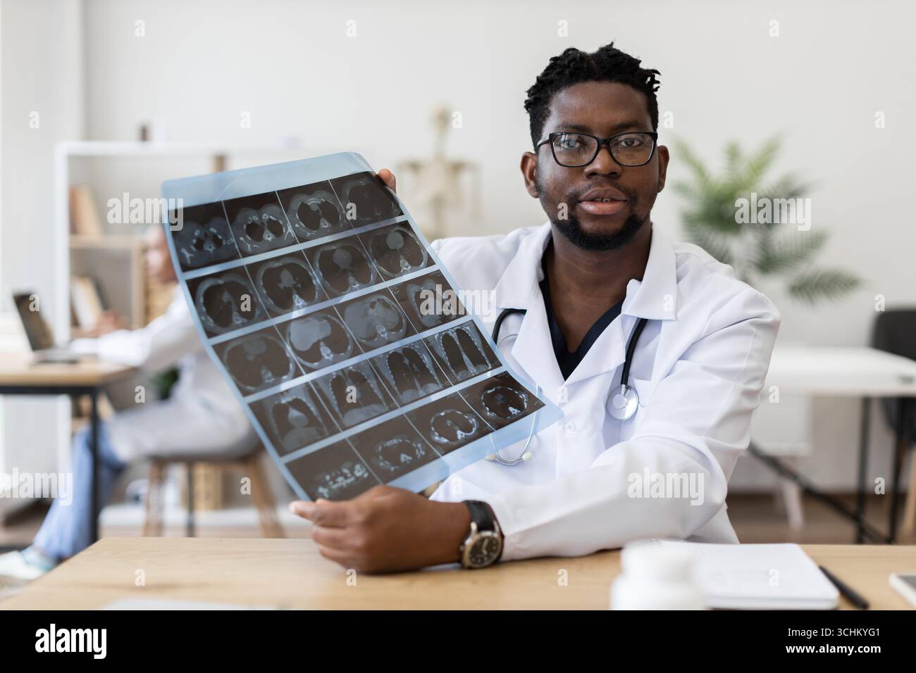 Male doctor analyzing diagnostic x-rays at workplace in medical office ...