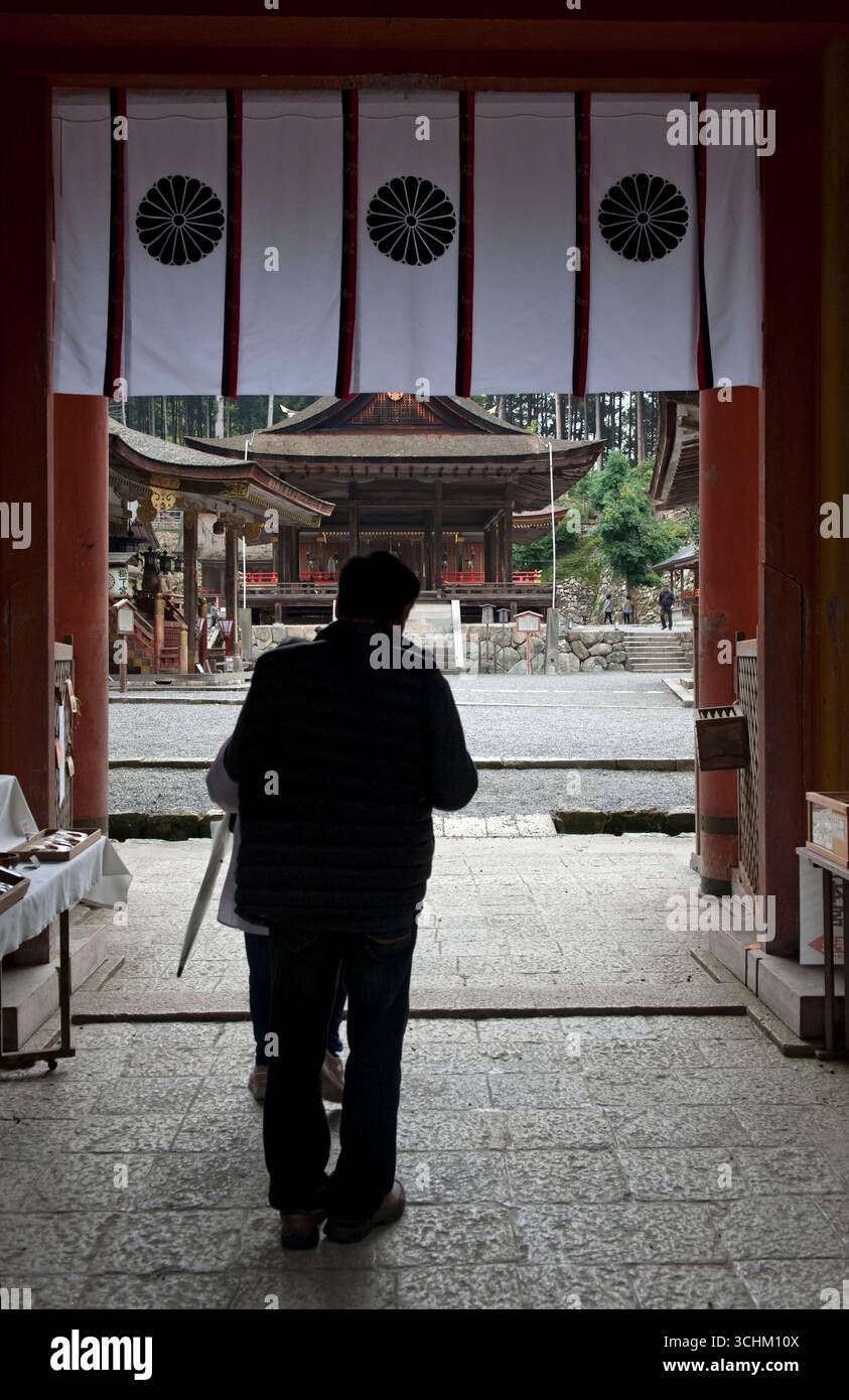 Japanese worshiper walking through shrine gate under the Imperial ...