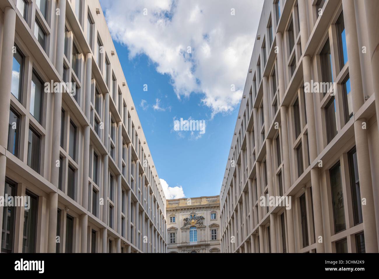 A modern street view between two symmetrical facades leading to a ...