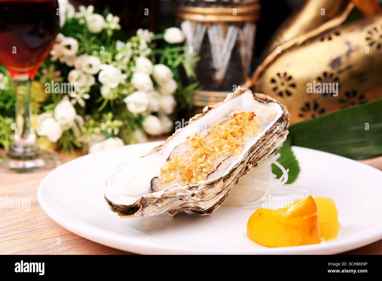 Garlic-Baked Oyster on Half Shell with Lemon Stock Photo - Alamy