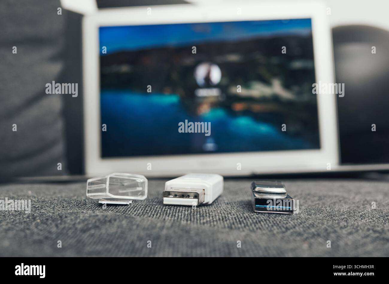 Three USB drives are placed on a couch next to a laptop Stock Photo - Alamy