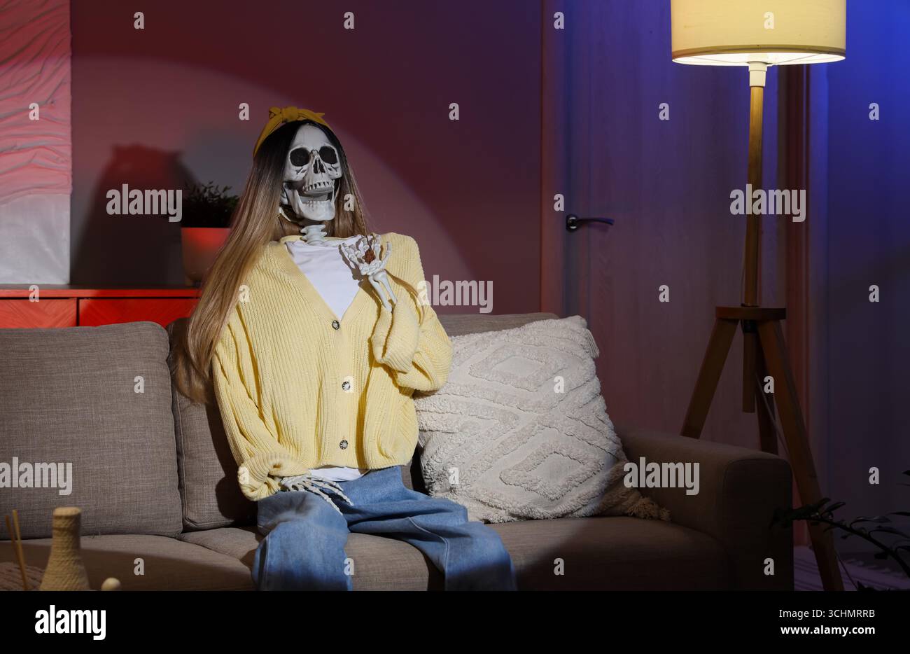 Human skeleton model dressed as woman sitting on sofa in living room at ...