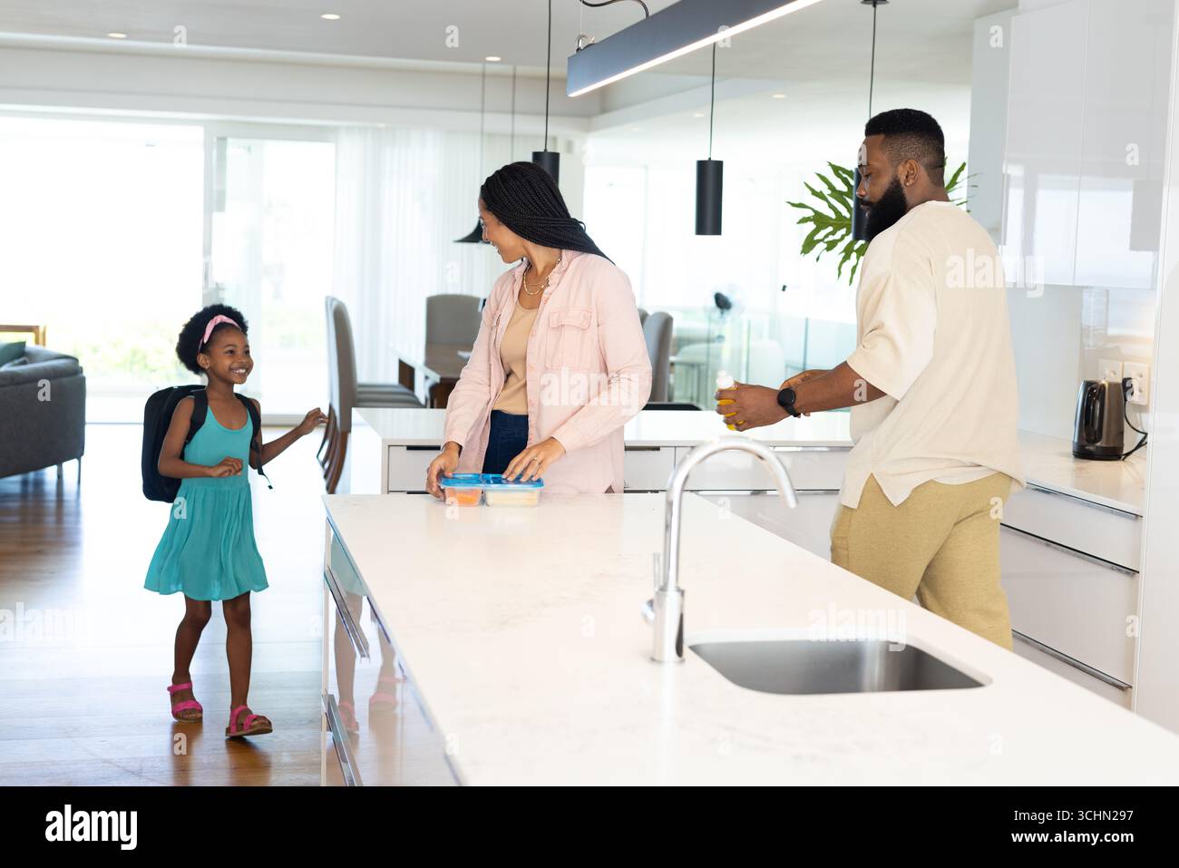 Family preparing for school, parents packing lunch while daughter ...