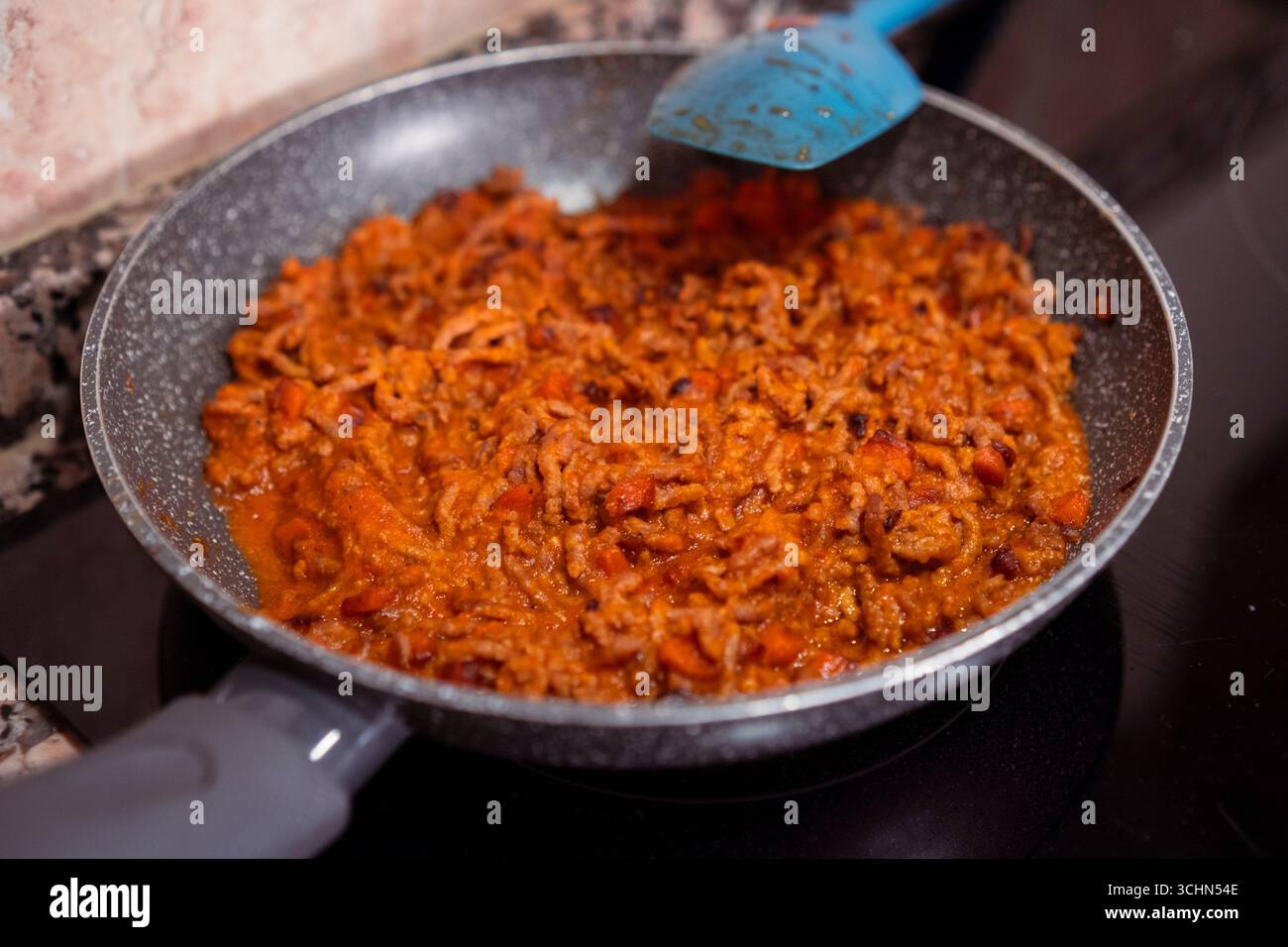 Mince meat with chopped carrots and homemade tomato sauce cooking on ...