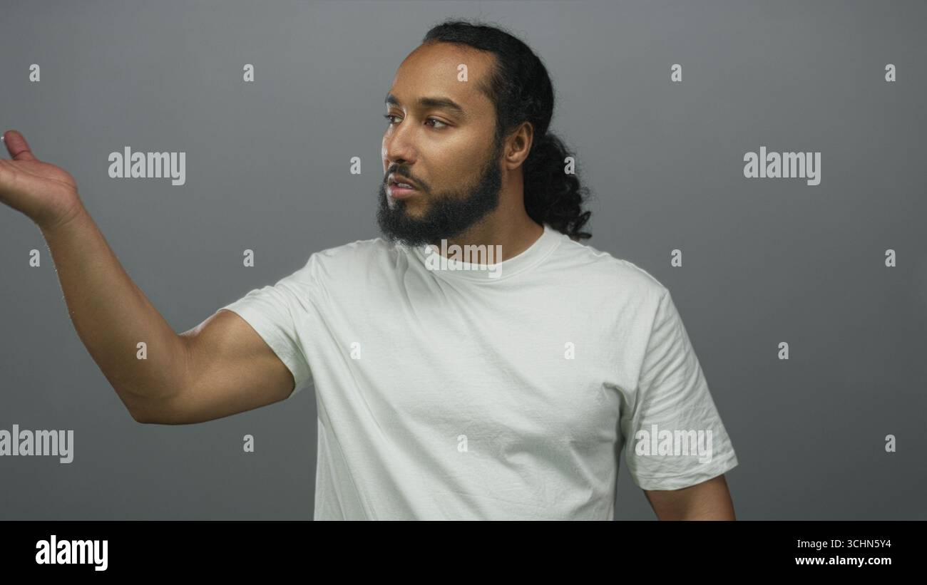 Bearded man shrugging with raised palms and closed eyes in a gray ...