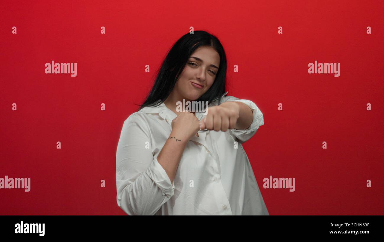 Young plus size woman boxing with confidence against a bold red ...