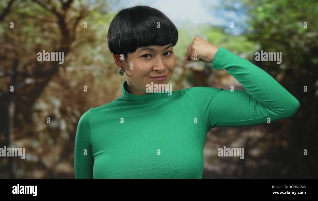Woman flexes confidently in green hi-res stock photography and images ...