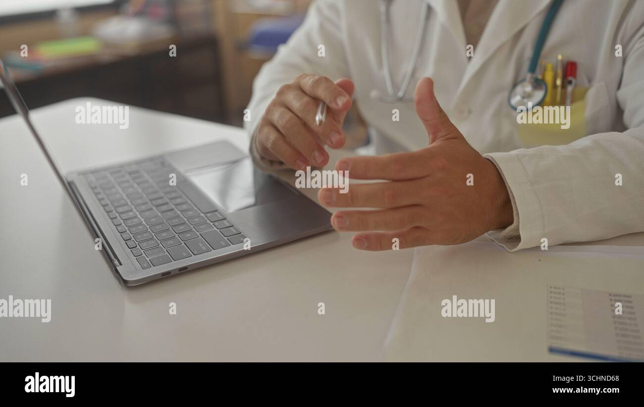 Man holds pen over laptop keyboard and gestures with both hands beside ...