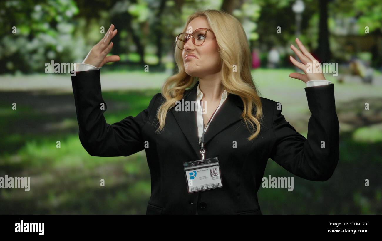 Woman in park making expressive gestures wearing glasses and id badge ...