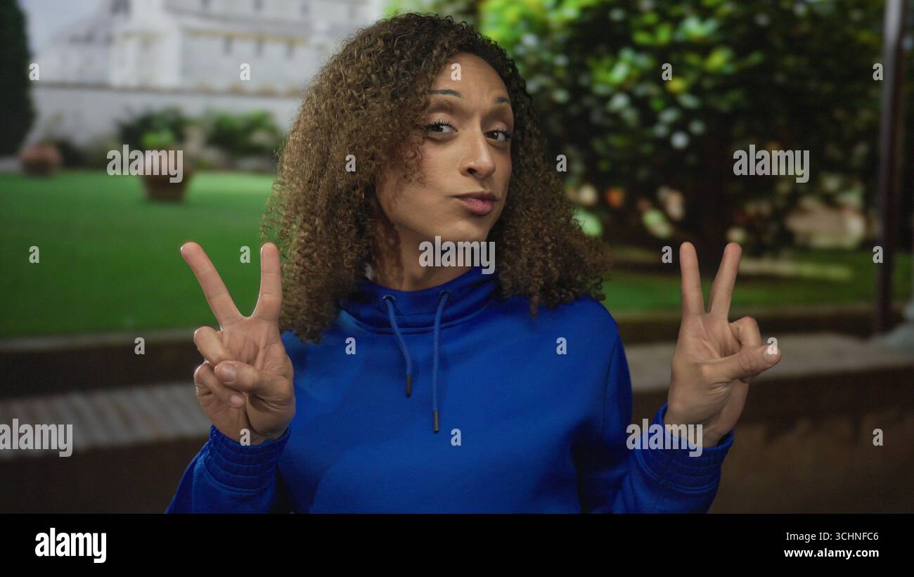 Transgender hispanic woman shows double peace sign with her hands on ...
