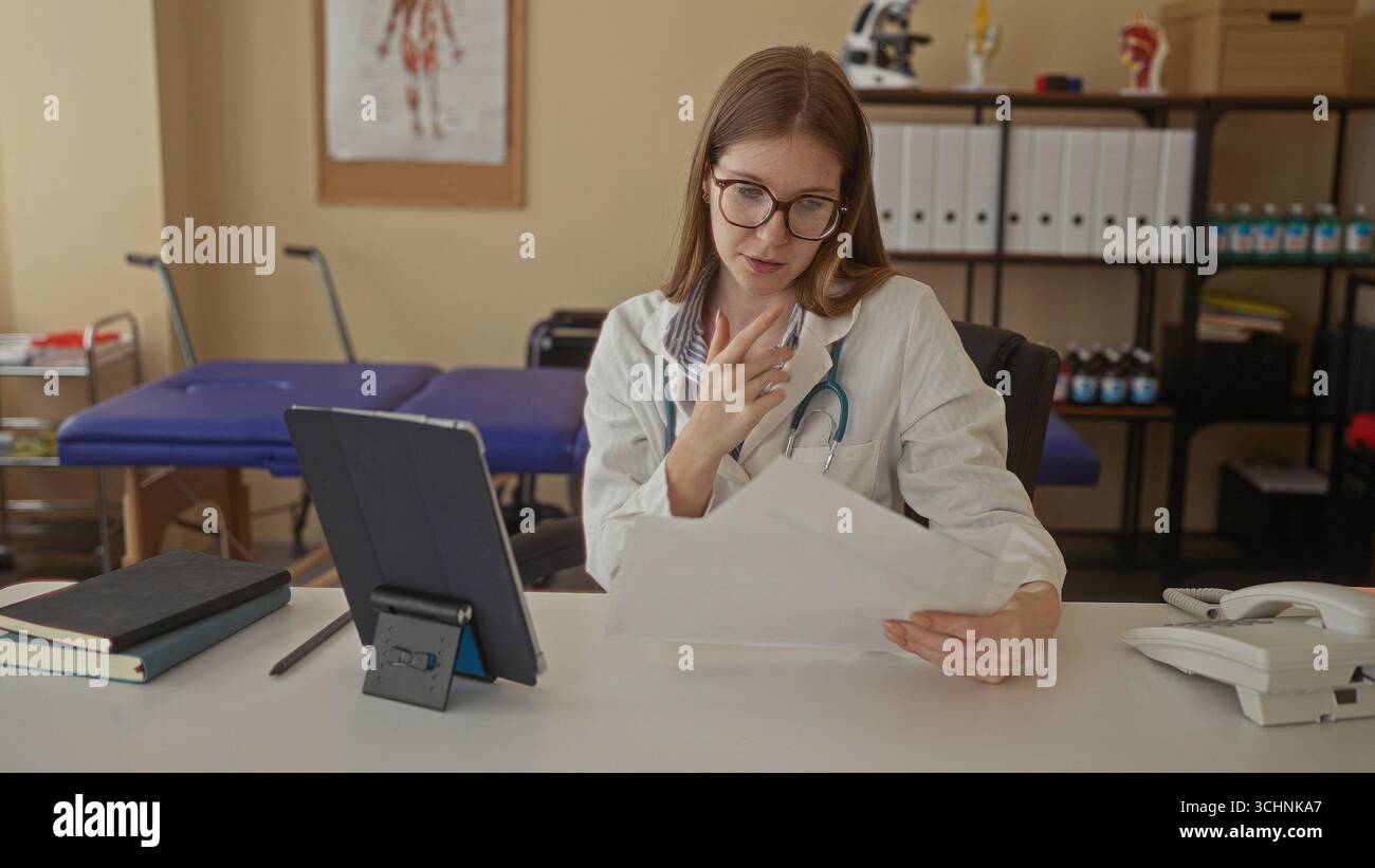 Woman doctor with stethoscope reviewing papers with hand on chin in ...