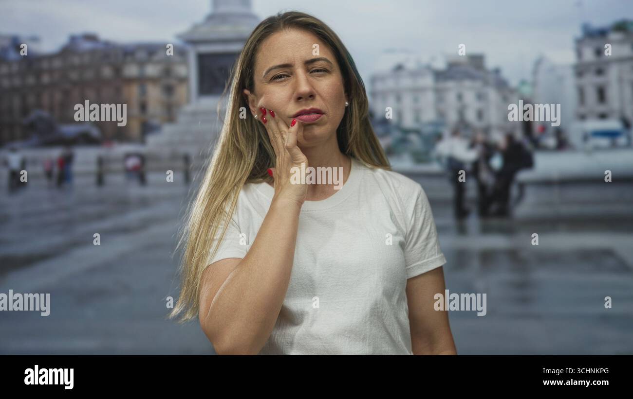 Woman touches cheek hand wincing hi-res stock photography and images ...