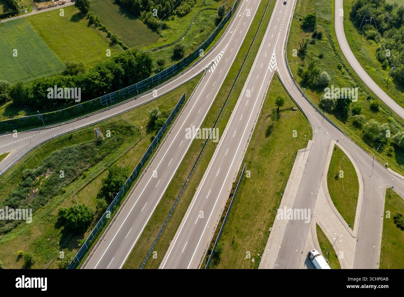 Top down view of empty multilane expressway and exit ramp surrounded by ...