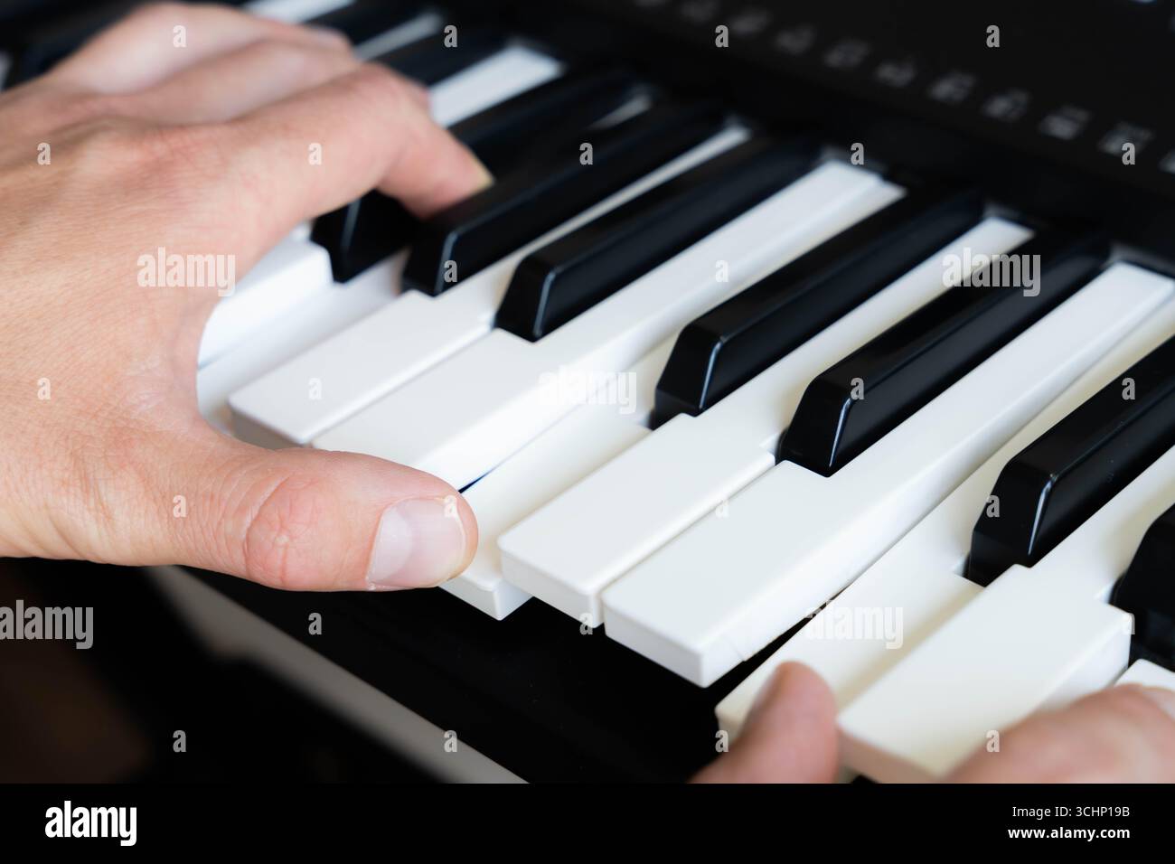 Close-up hands on piano keyboard showing active fingers playing music ...