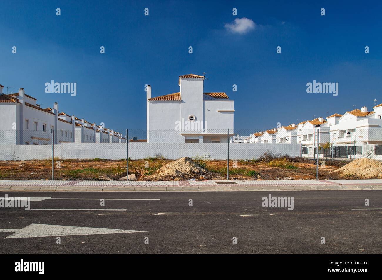 White-painted row houses with red tile roofs line quiet streets in the ...