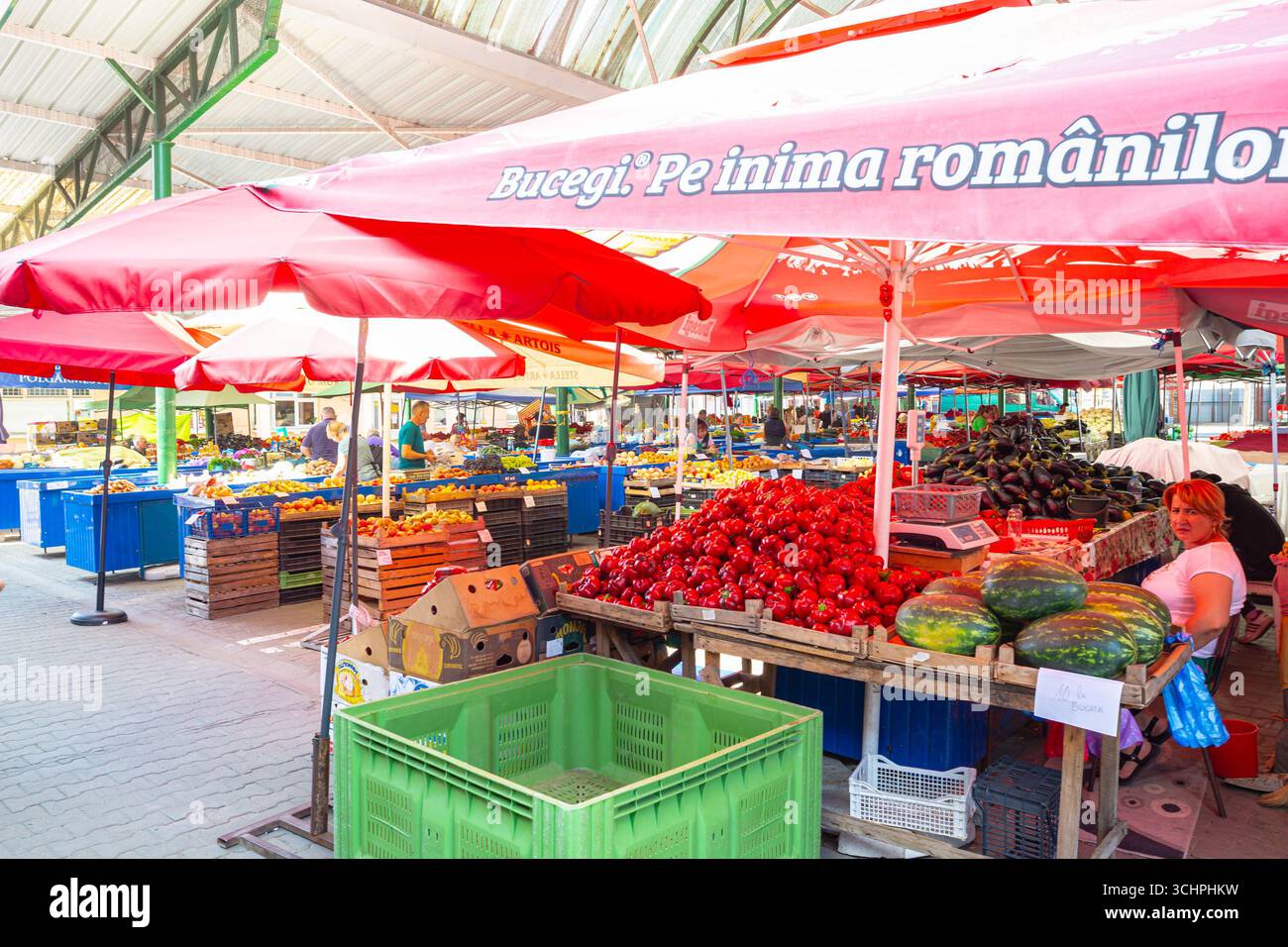 Outdoor market stall with fresh vegetables and fruits under colourful ...