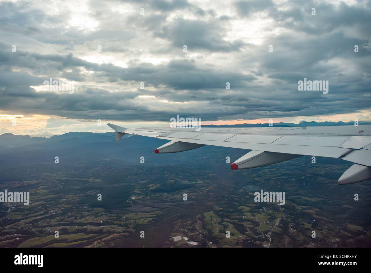 A stunning aerial view showcasing the wing of an airplane above the ...