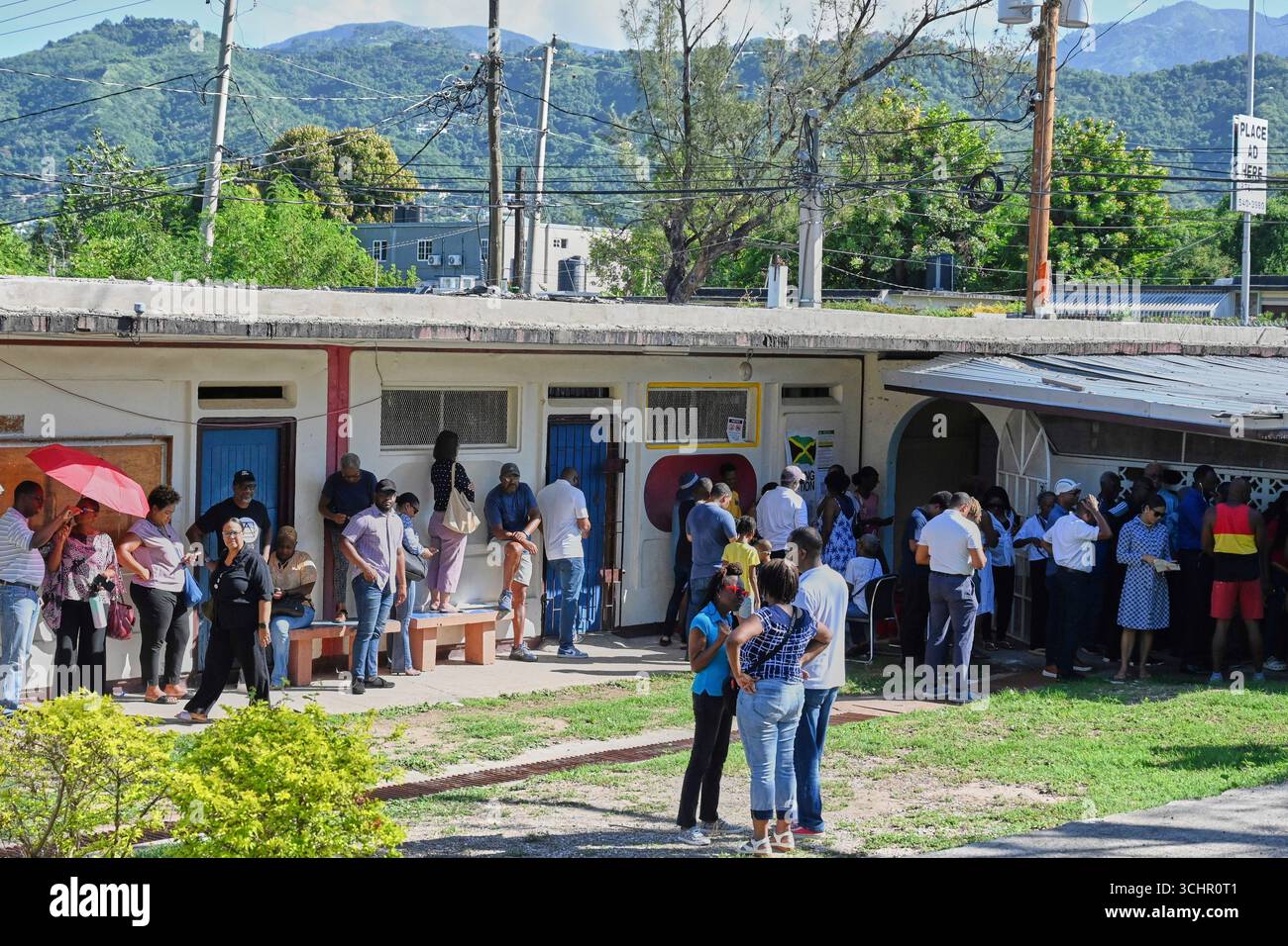 People stand in line to vote at a polling station during general ...