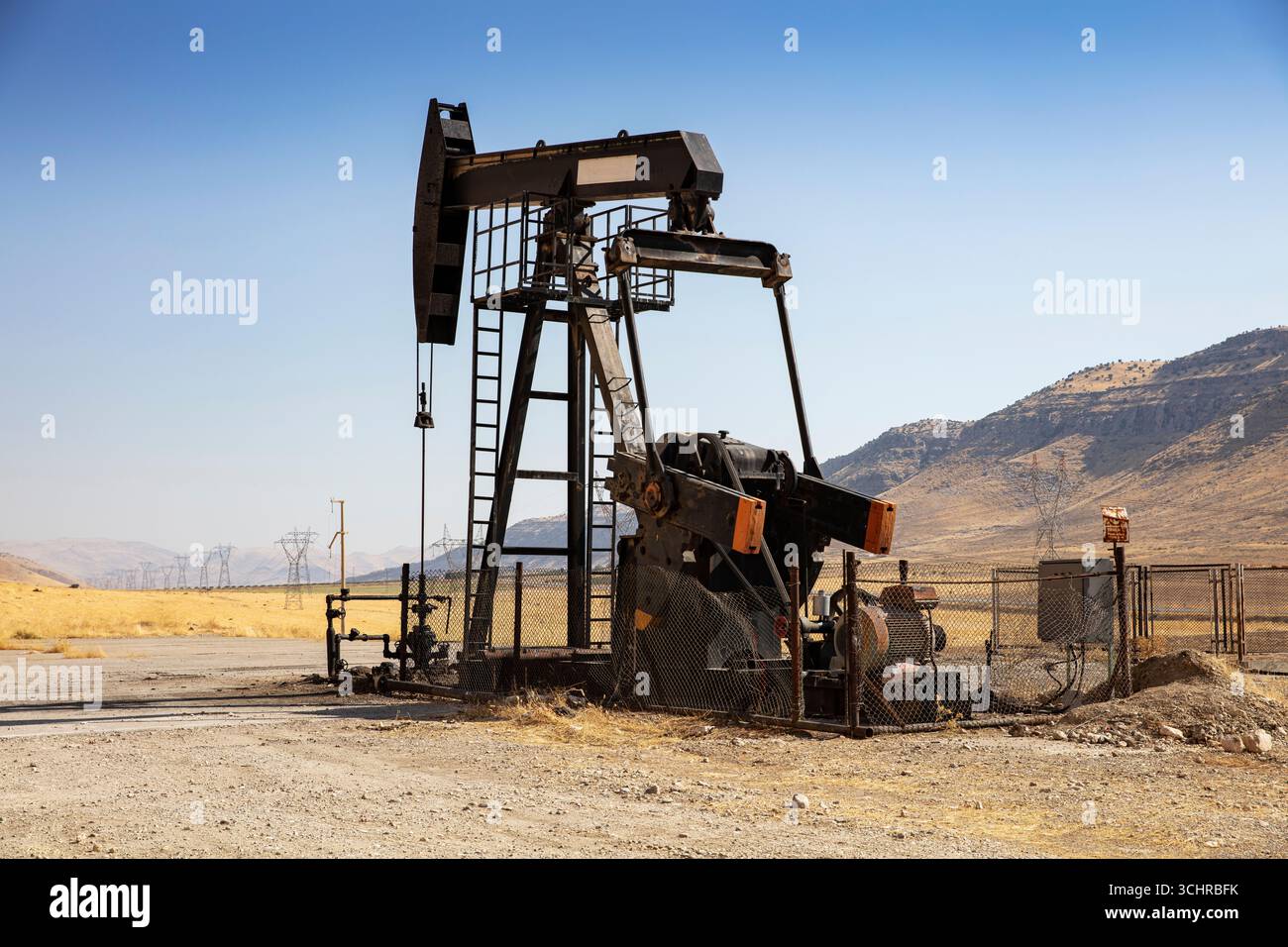 Oil drilling derricks at desert oilfield. Crude oil production from the ...