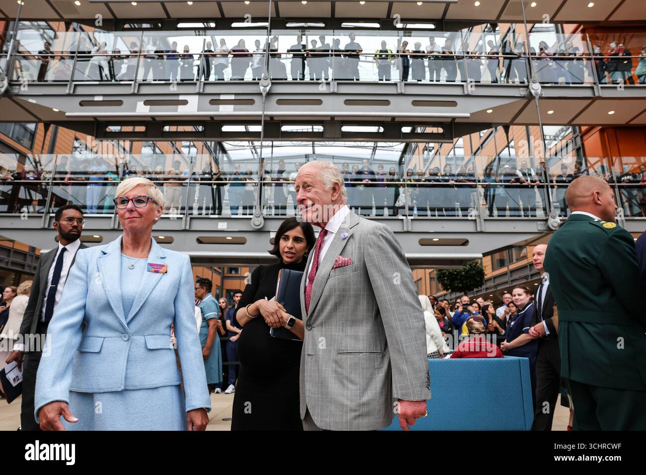 Staff, visitors and patients line the walkways to see King Charles III ...