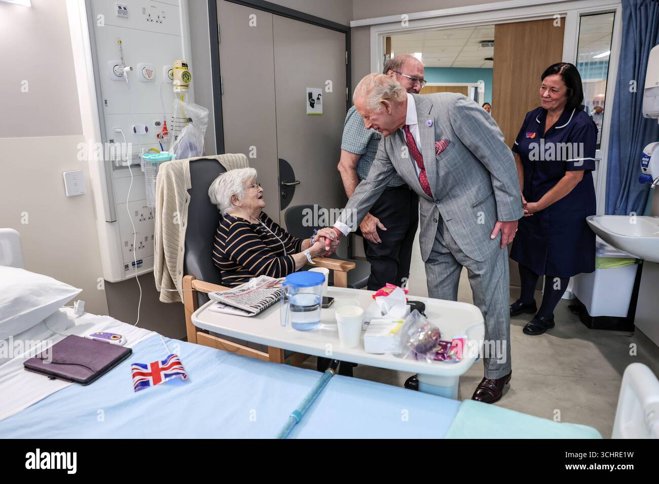 King Charles III talks with patient Jacqueline Page as he visits a ward ...